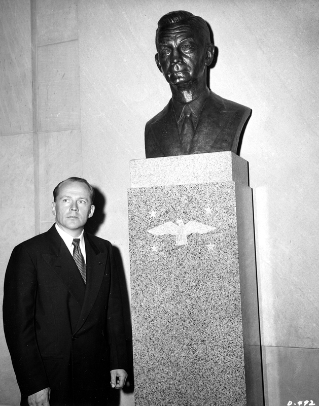 An unidentified man standing before the bust and plaque honoring James ...
