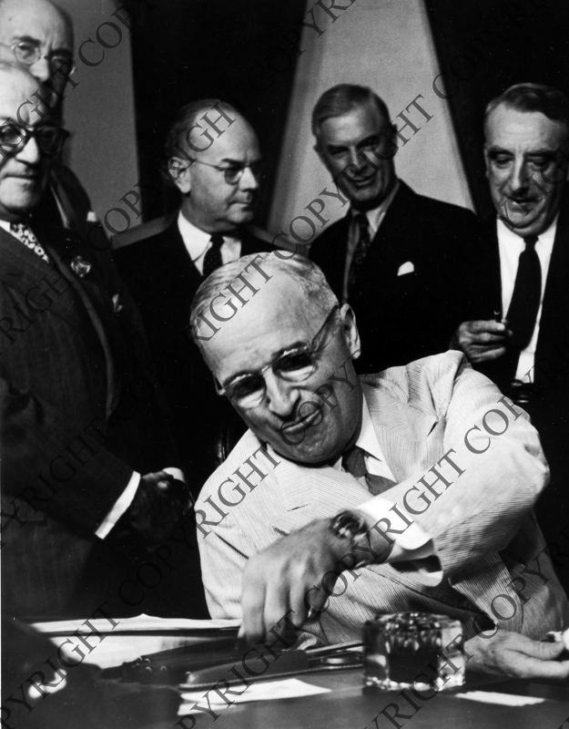 President Truman reaches for another pen at the signing of the British ...