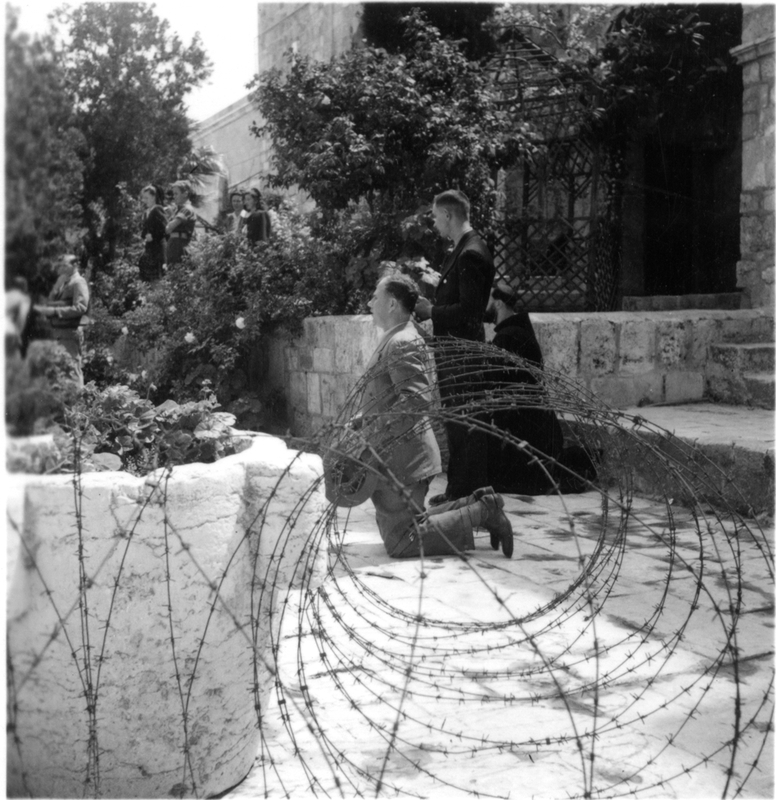A Photograph of Three Worshipers Behind a Barbed Wire Barrier | Harry S ...