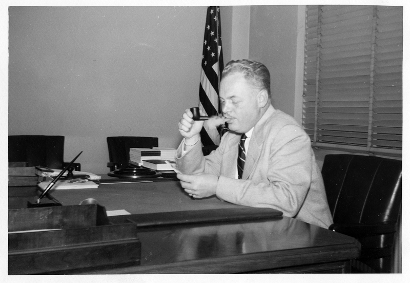 Conrad G. Hugh Smoking a Pipe at Desk | Harry S. Truman
