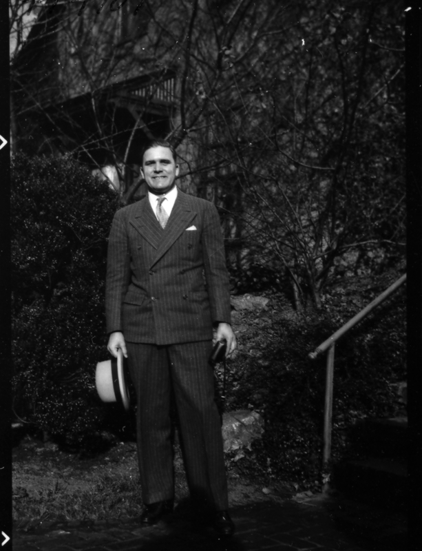 Snapshot of James E. Webb standing at the bottom of stairs of a ...