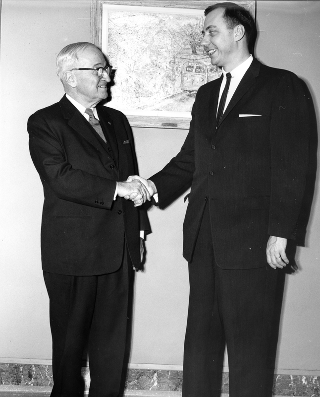 Former President Truman shakes hands with an unidentified individual at ...