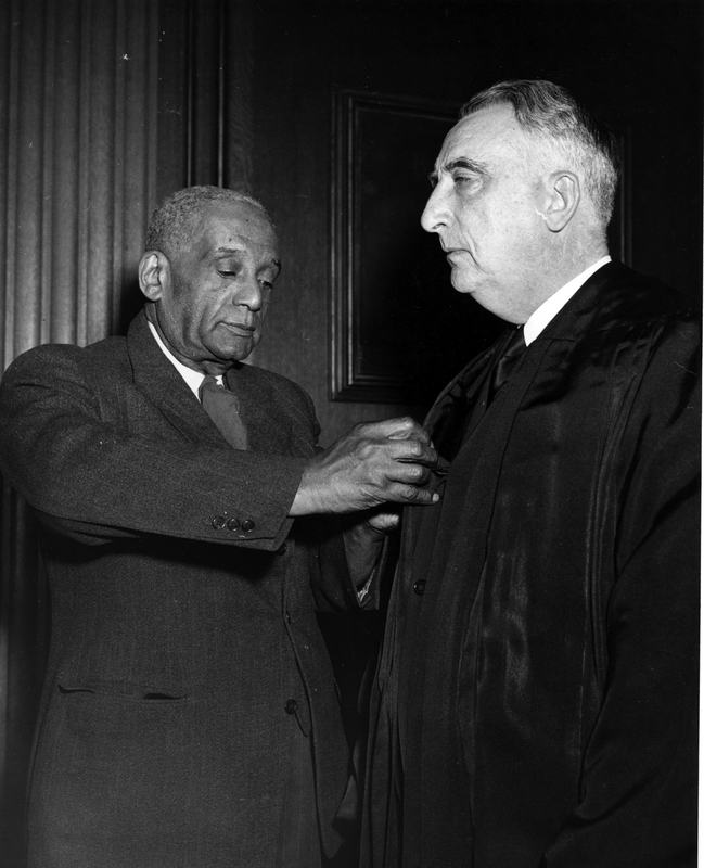 Chief Justice Fred M. Vinson being aided with his robes by Robert H ...