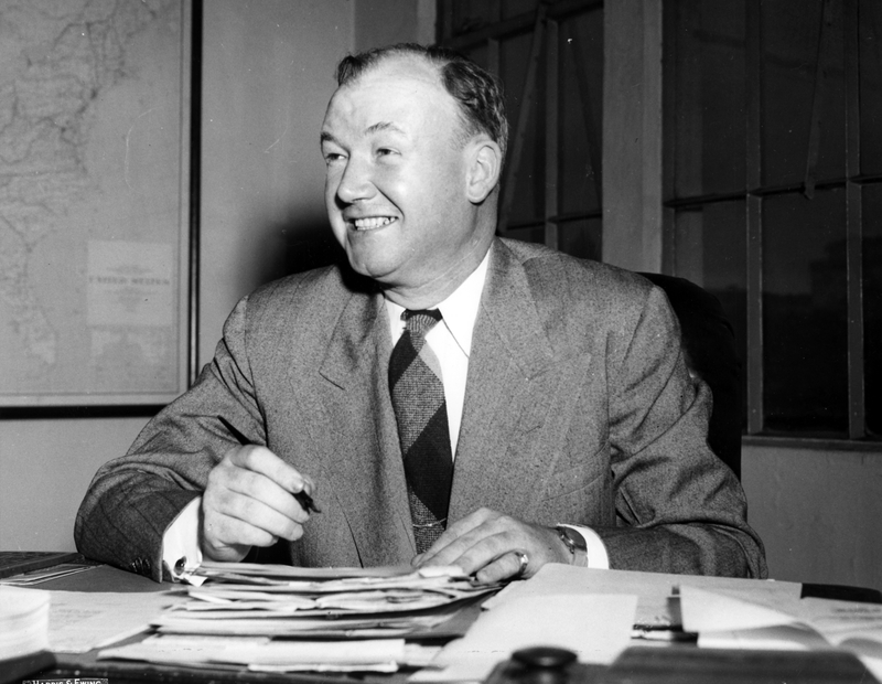 Portrait at desk of Tighe E. Woods, Housing Expediter | Harry S. Truman