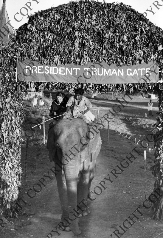 Two unidentified men riding an elephant through the "President Truman ...