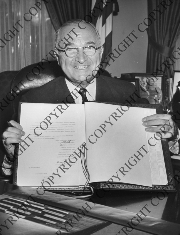 President Harry S. Truman holding copy of the Japanese Peace Treaty ...