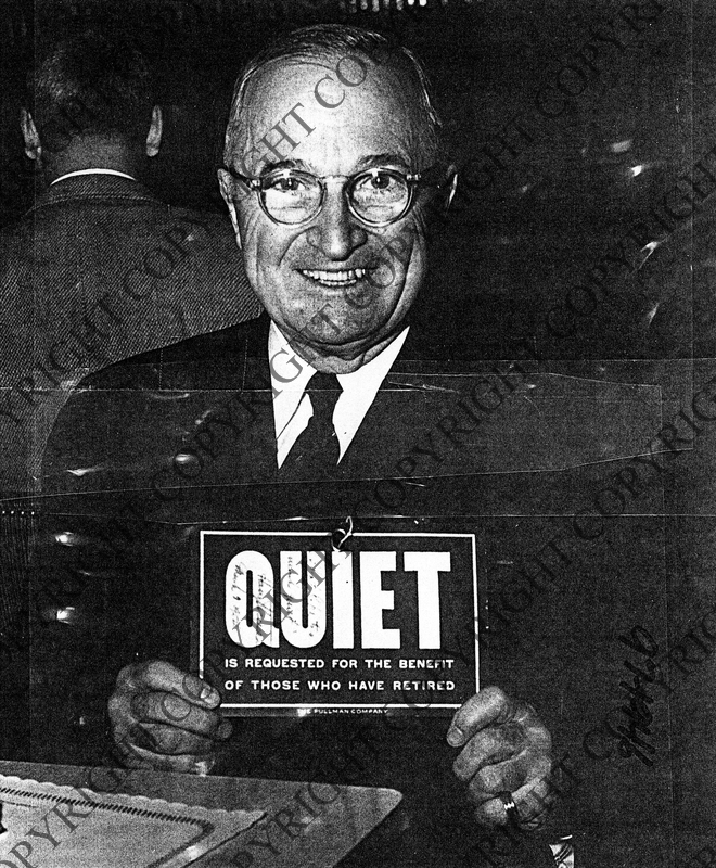 Former President Truman displays a broad grin as he holds a sign which ...