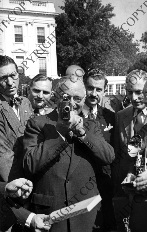 President Truman pointing his new movie camera at the photographer ...