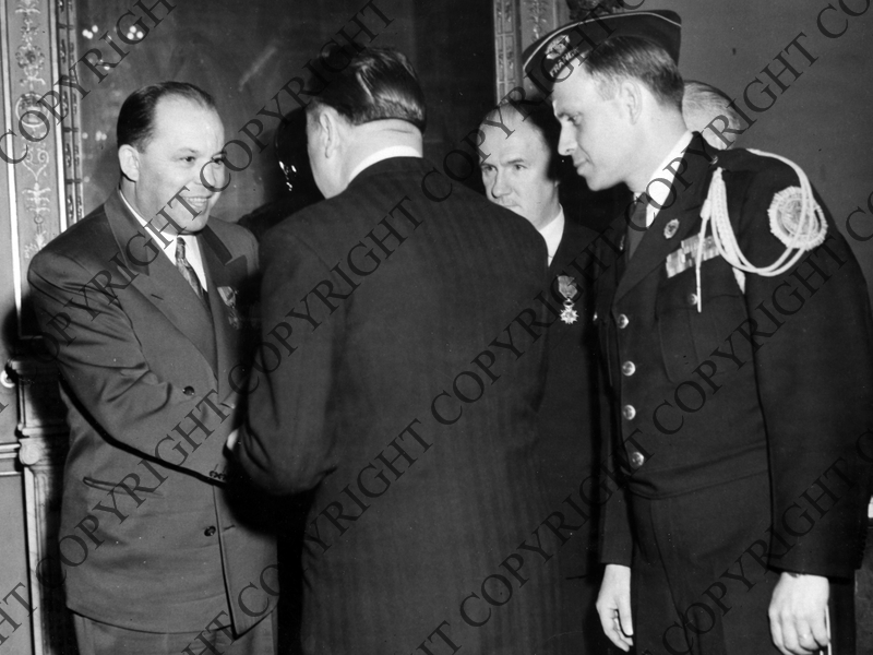 Assistant Secretary of Defense Paul Griffith is shown with unidentified ...